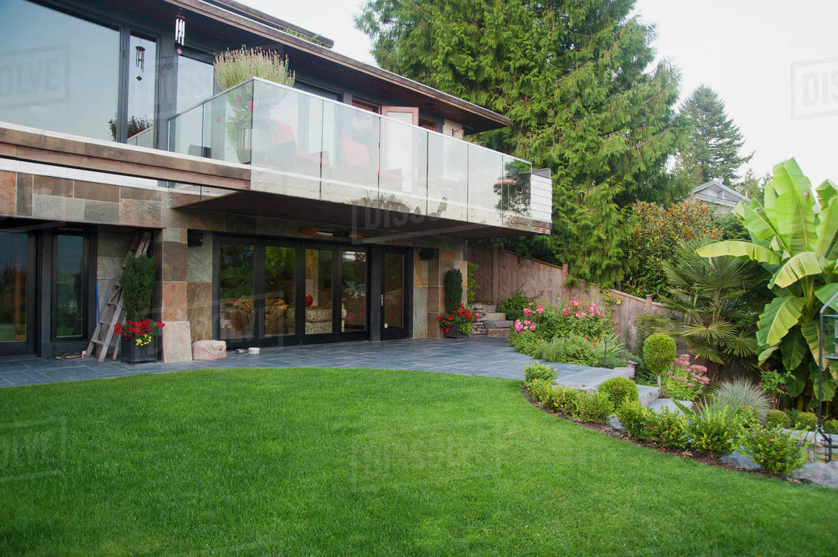 Green lawn behind modern home - Stock Photo - Dissolve