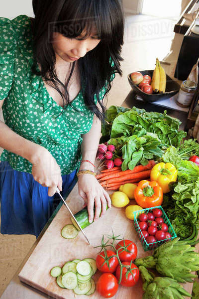 Woman chopping vegetables in kitchen - Stock Photo - Dissolve