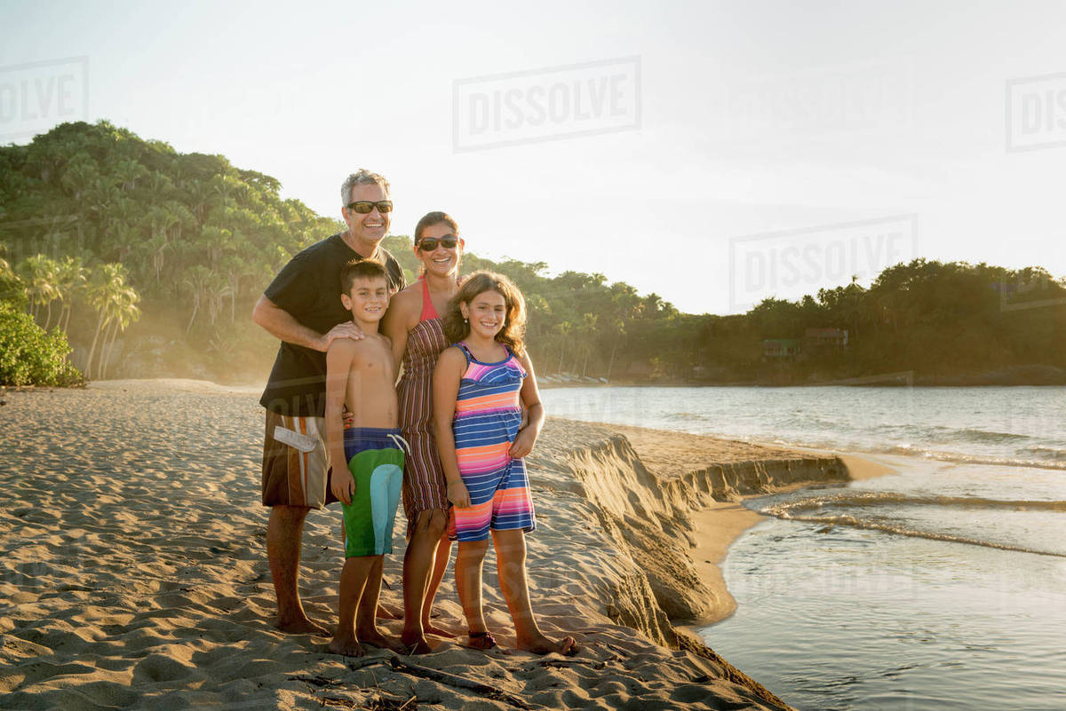 Family standing together on beach - Royalty-free Stock Photo | Dissolve