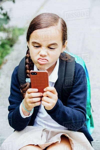 Mixed race girl making a face at cell phone - Royalty-free Stock Photo ...