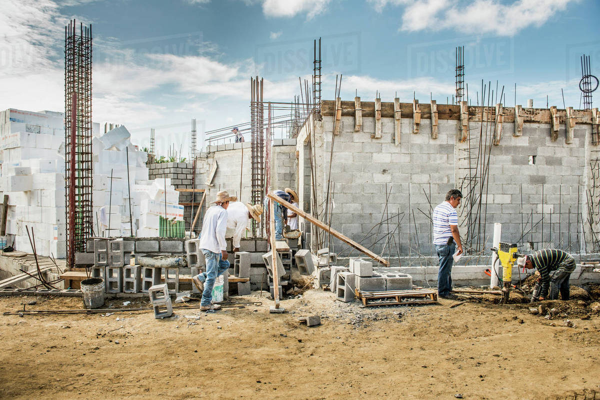 Construction workers building cinder block wall - Stock Photo - Dissolve