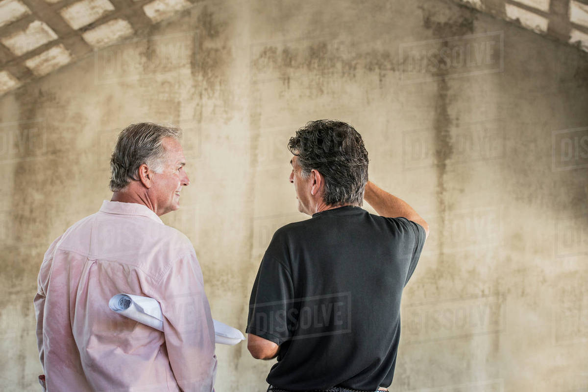 Caucasian architects talking near wall - Royalty-free Stock Photo ...
