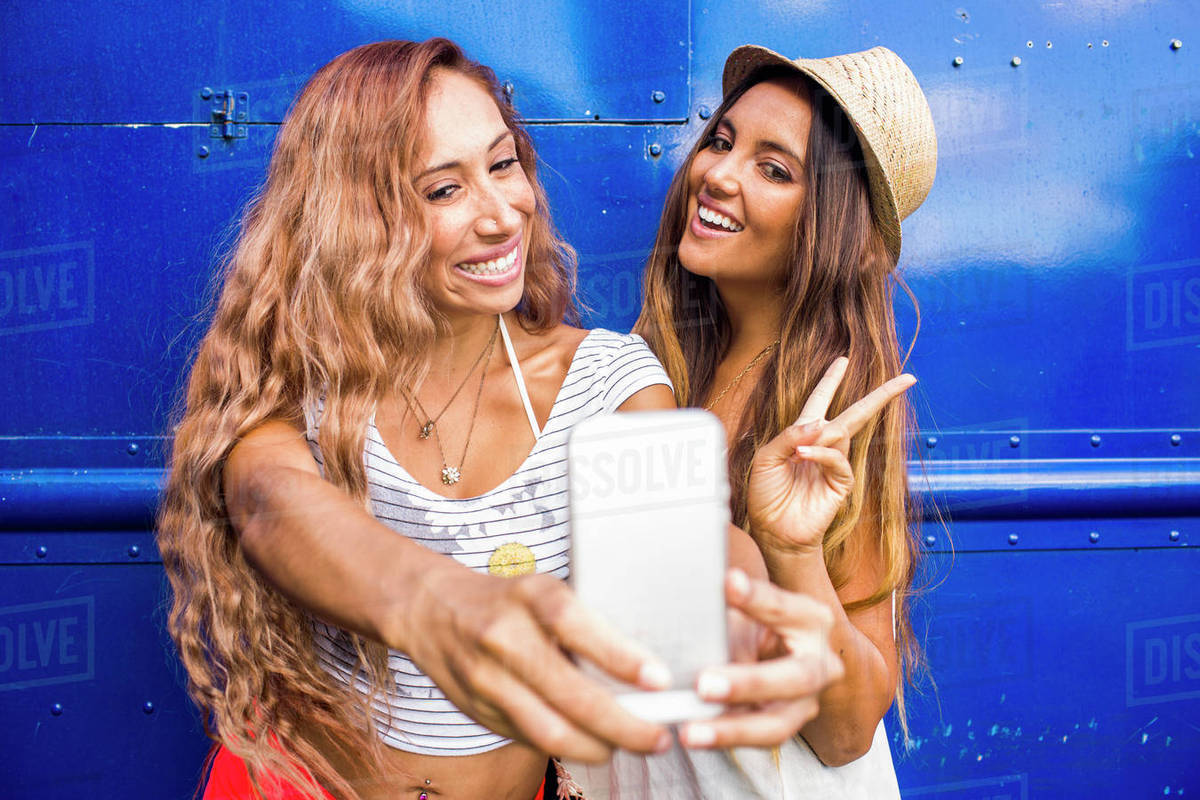 Women taking cell phone photograph together - Royalty-free Stock Photo ...