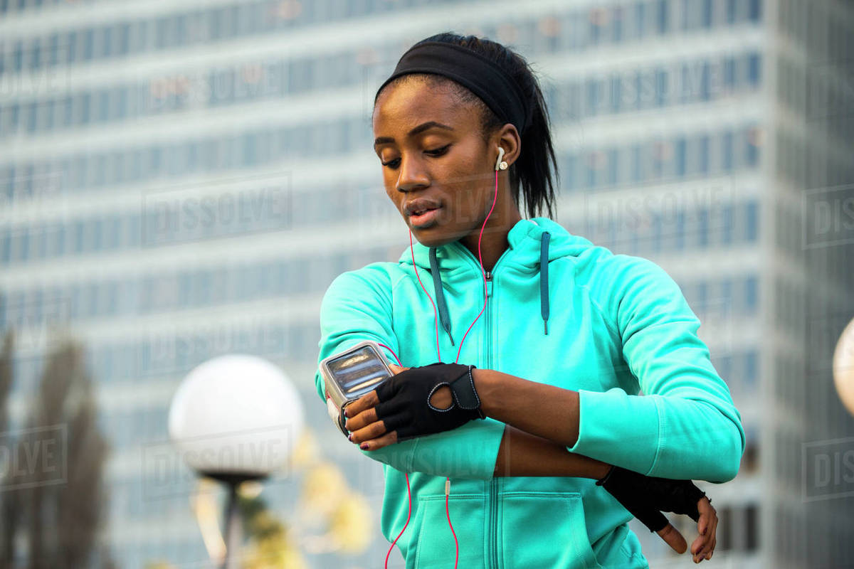 Black runner using cell phone near high rise buildings - Stock Photo ...