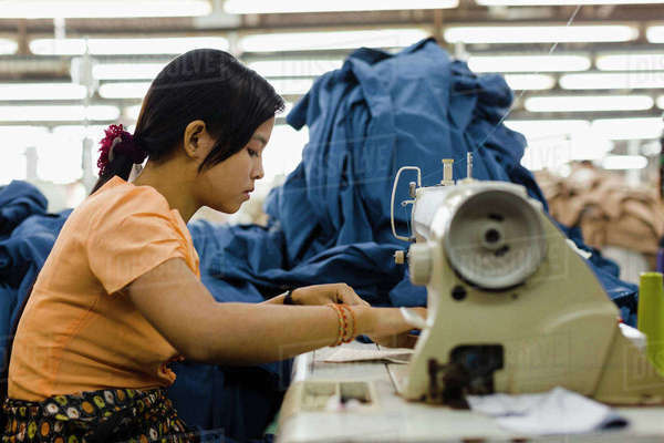 Asian worker sewing clothing in garment factory - Stock Photo - Dissolve