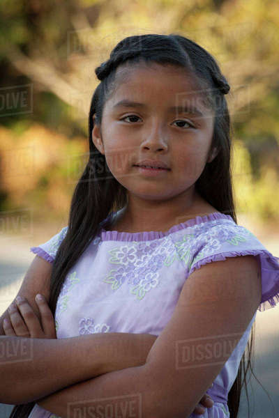 Hispanic girl standing with arms crossed - Stock Photo - Dissolve