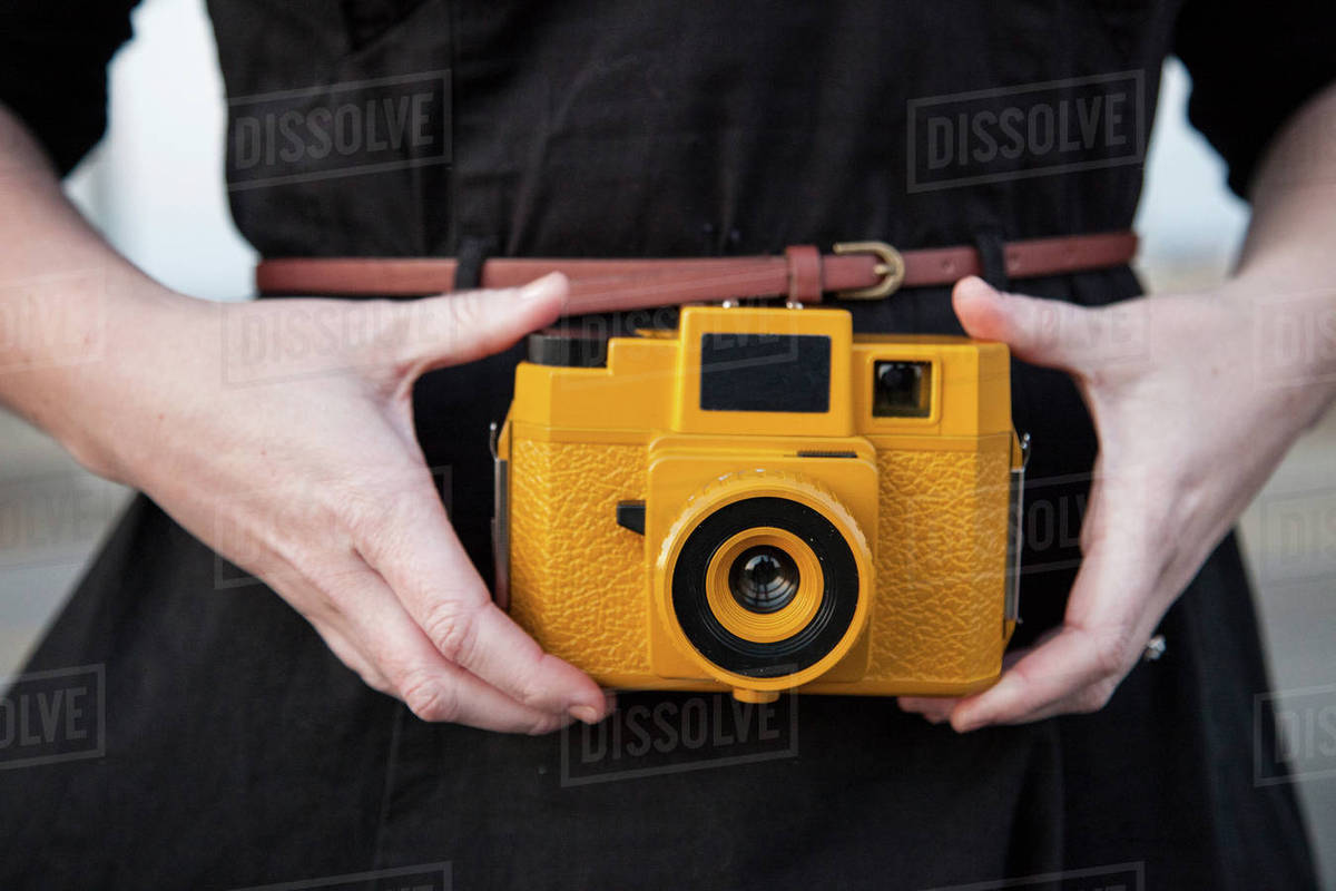 Close up of Black woman holding plastic camera - Stock Photo - Dissolve