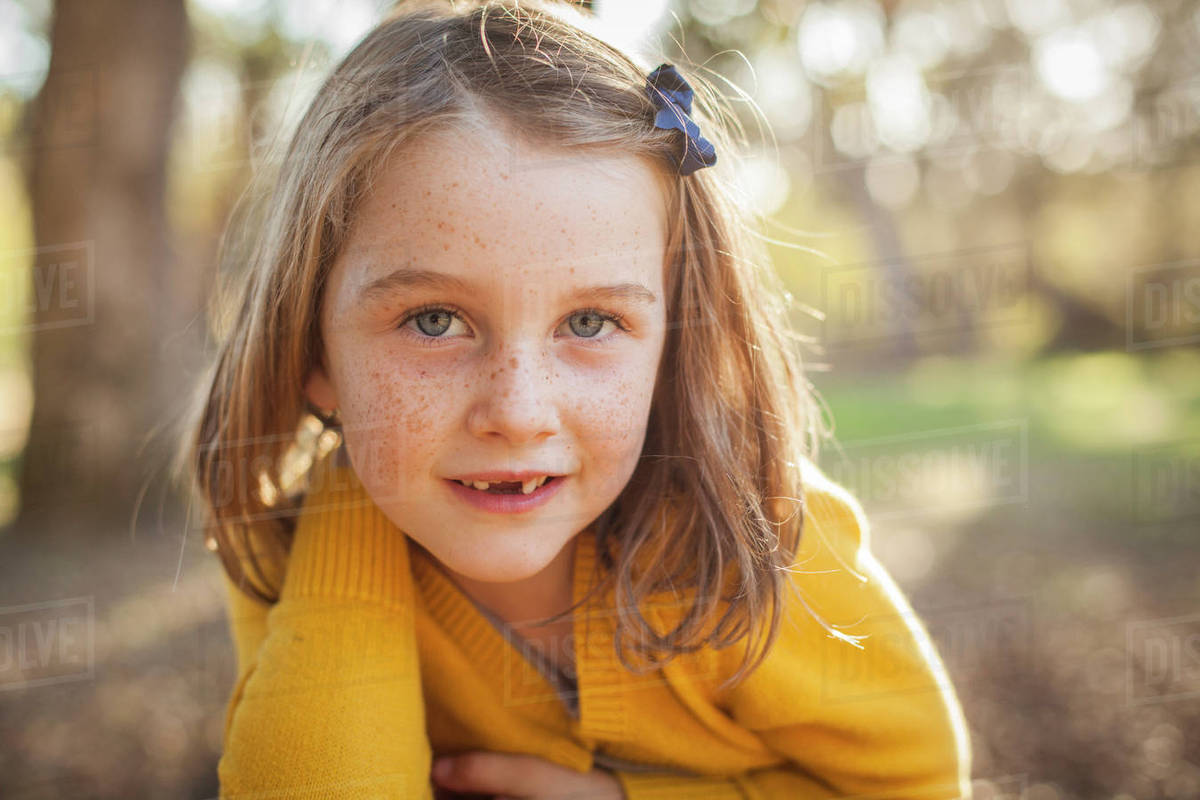 Close up of smiling girl laying in field - Stock Photo - Dissolve