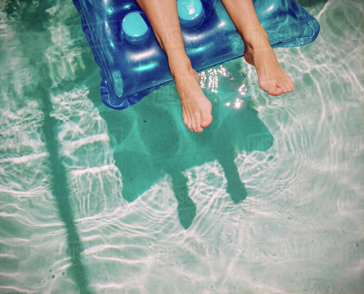 Feet of Caucasian woman floating on raft in swimming pool - Stock Photo ...