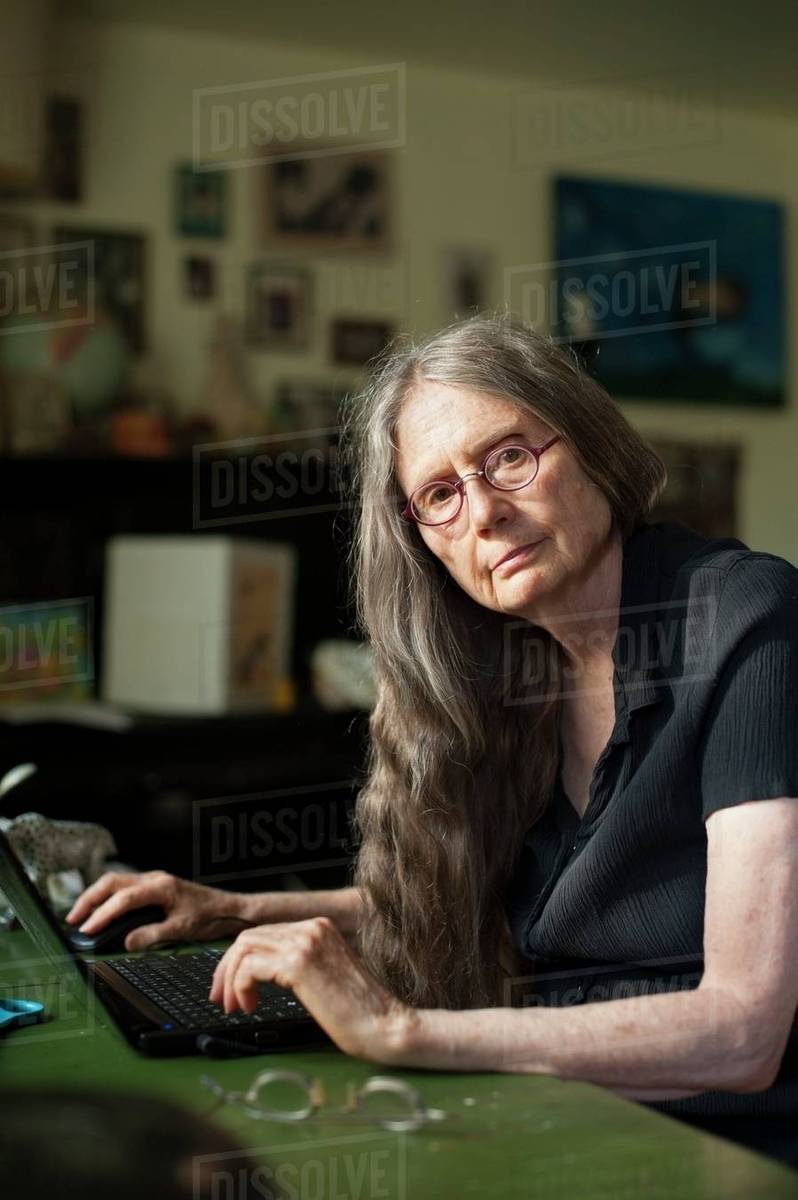 Older woman using laptop at desk - Stock Photo - Dissolve