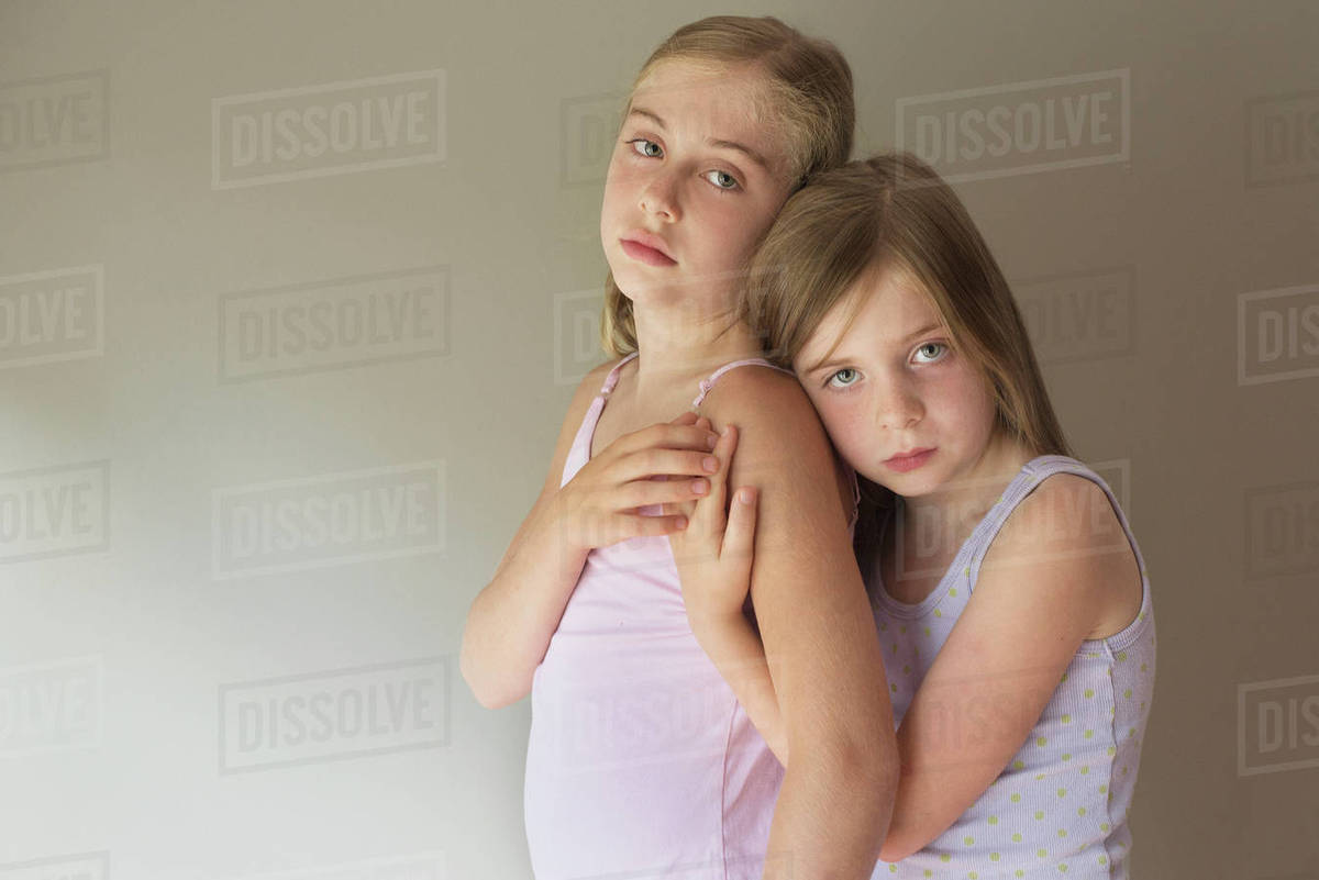 Serious Caucasian girls hugging - Stock Photo - Dissolve