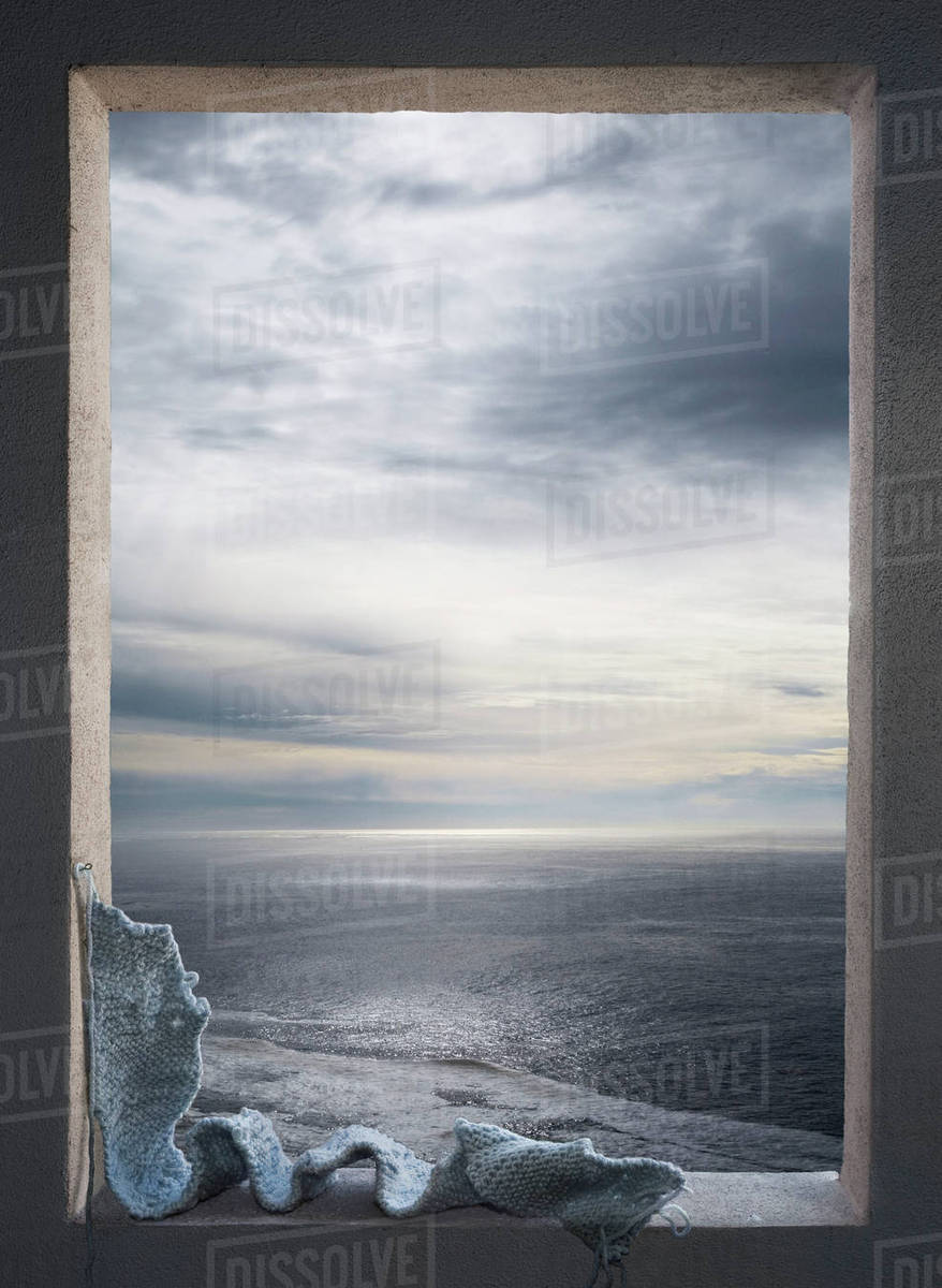 Knitted scarf in window over seascape - Stock Photo - Dissolve