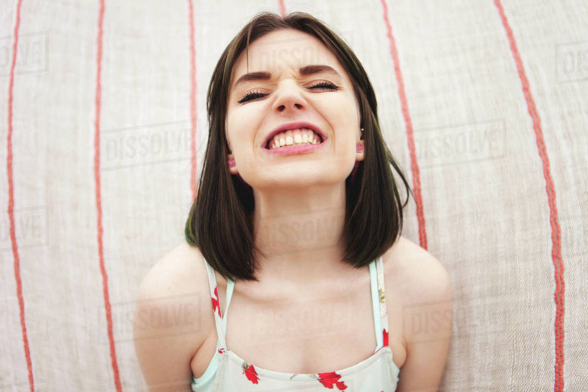 Caucasian woman grinning with bared teeth - Stock Photo - Dissolve