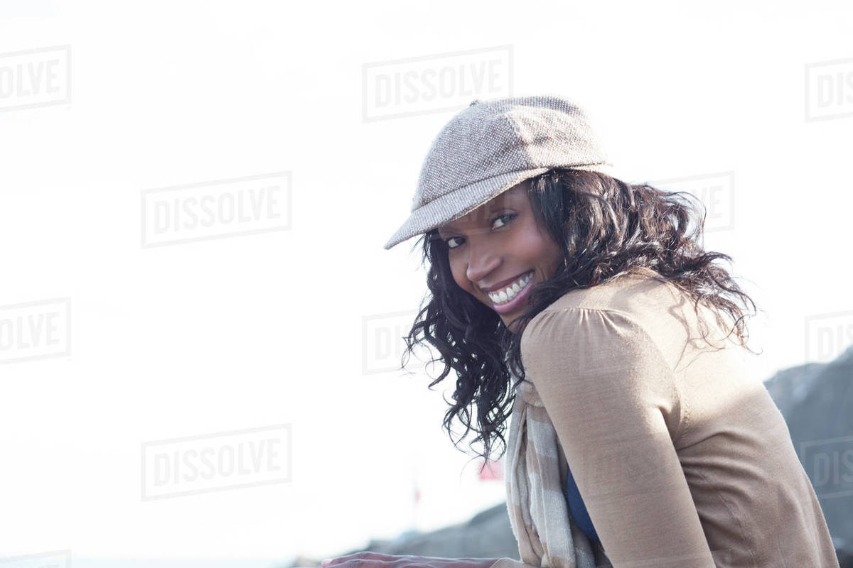 Close up of smiling woman wearing cap outdoors - Stock Photo - Dissolve