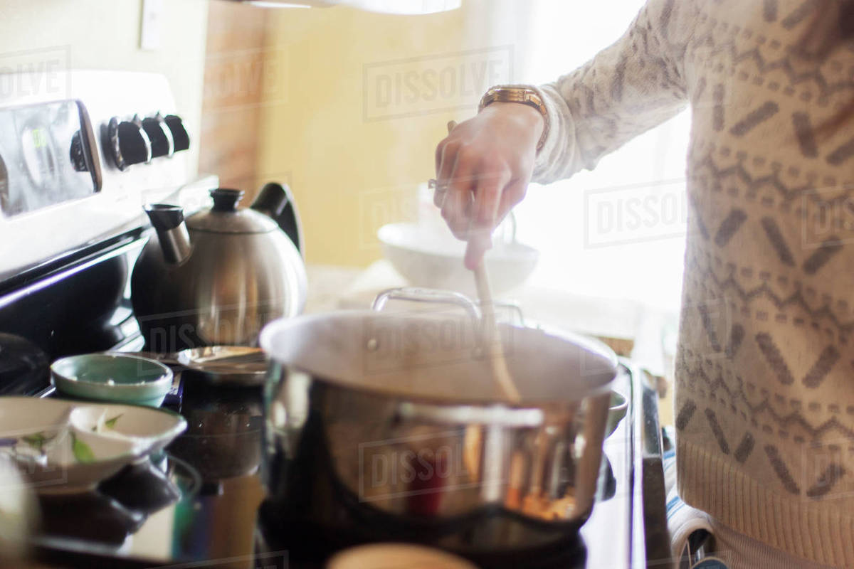 Close up of woman cooking in kitchen - Stock Photo - Dissolve