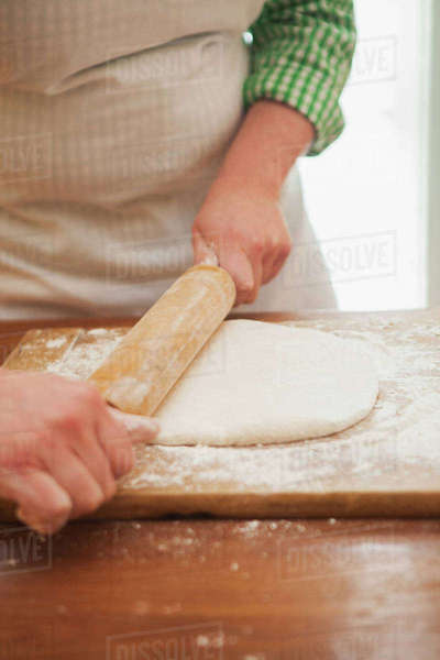 Baker rolling dough on counter - Stock Photo - Dissolve