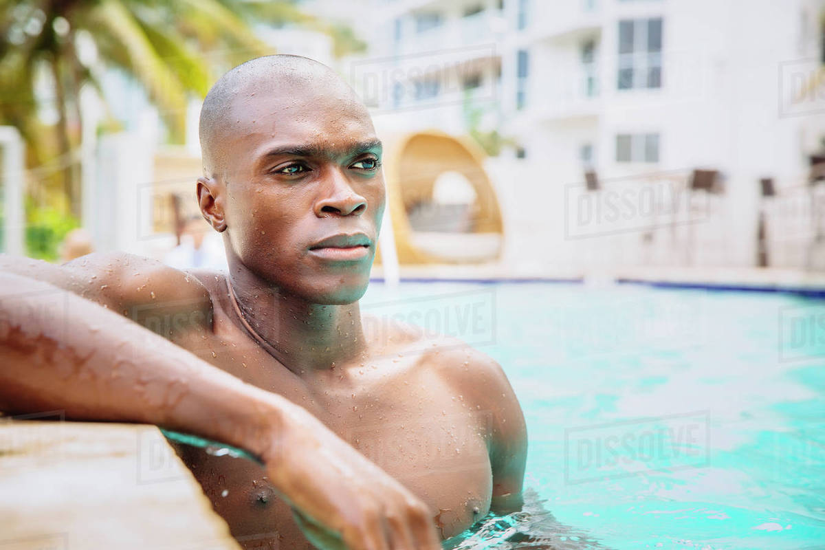 Black man standing in swimming pool - Royalty-free Stock Photo | Dissolve