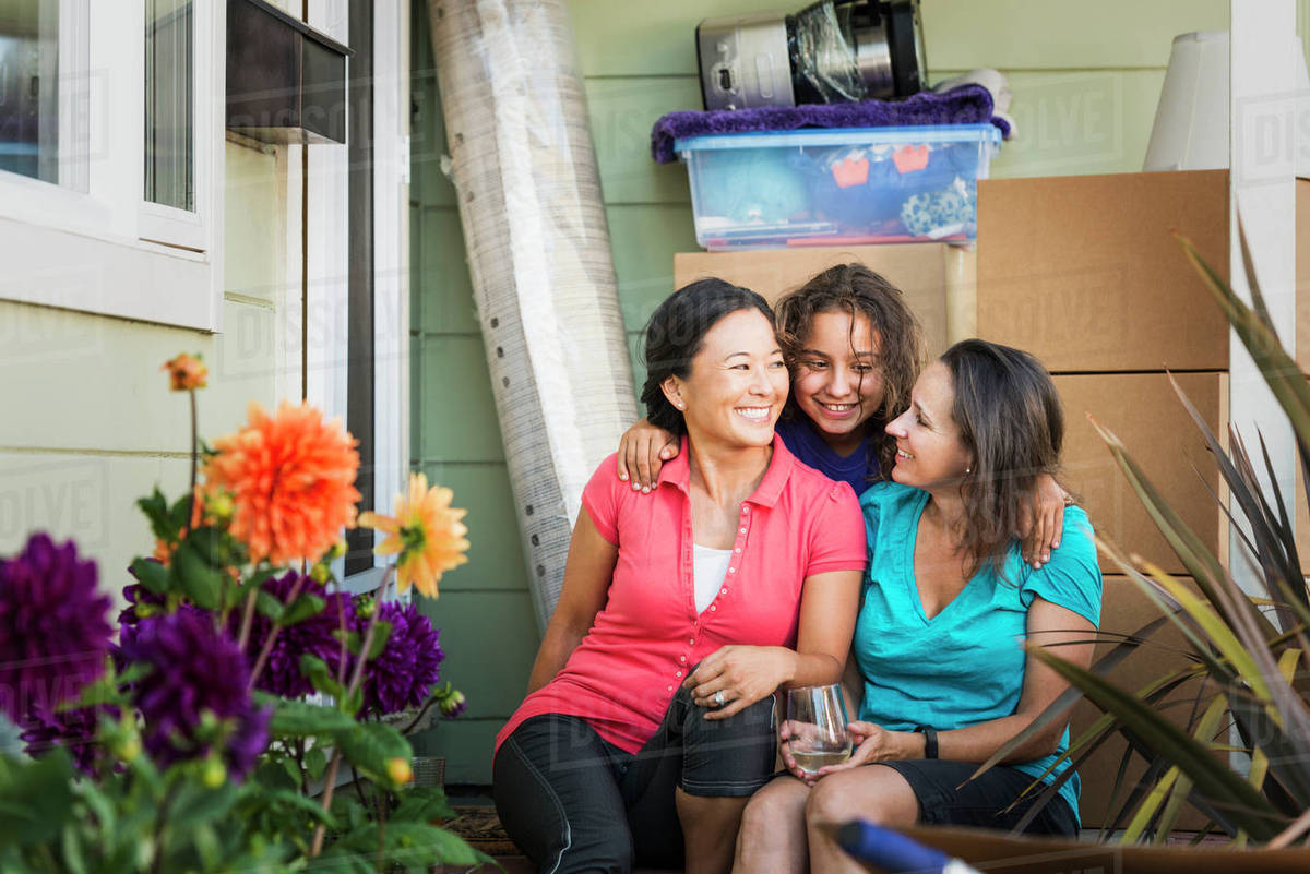 Family hugging outside house - Royalty-free Stock Photo | Dissolve