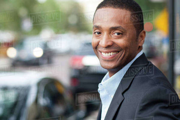 Black businessman smiling in city - Royalty-free Stock Photo | Dissolve