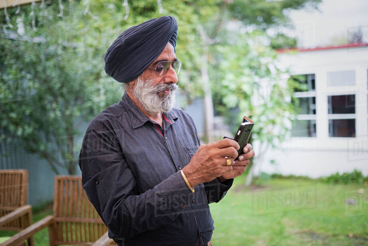 Indian man texting on cell phone - Royalty-free Stock Photo | Dissolve
