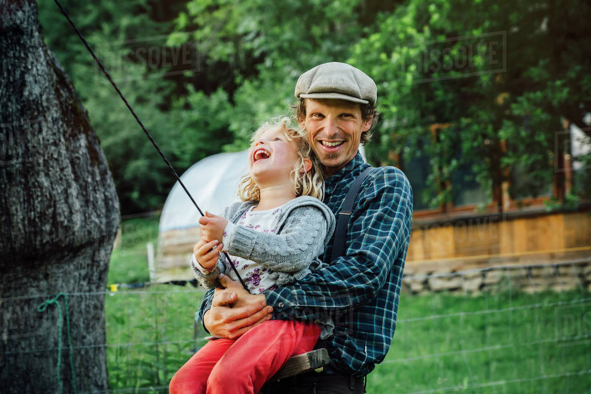 Caucasian man hugging daughter on rope swing - Royalty-free Stock Photo ...