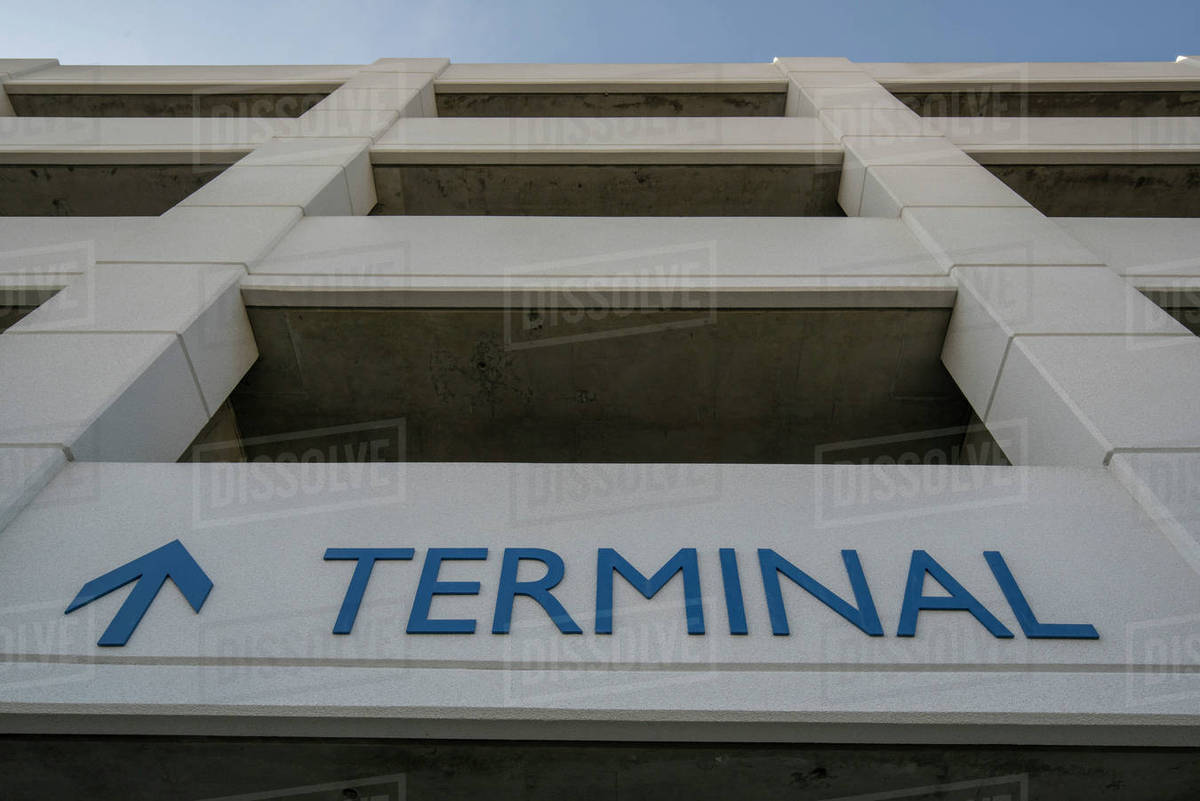 Arrow and terminal sign on parking garage - Stock Photo - Dissolve