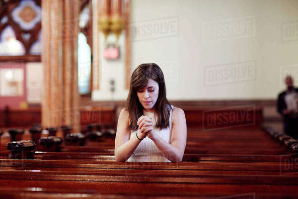 Kneeling Caucasian woman praying in church pew - Royalty-free Stock ...