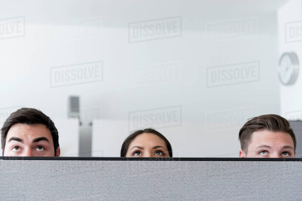 Eyes of business people looking up over cubicle wall in office - Stock ...