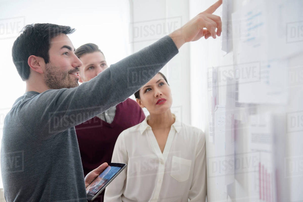 Business people talking about paperwork on wall - Royalty-free Stock ...