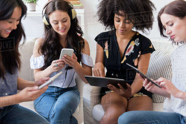 Women using technology in livingroom - Royalty-free Stock Photo | Dissolve