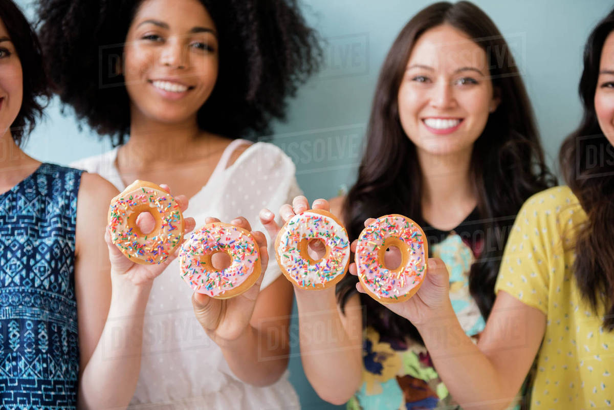 Portrait of smiling women posing with donuts - Royalty-free Stock Photo ...