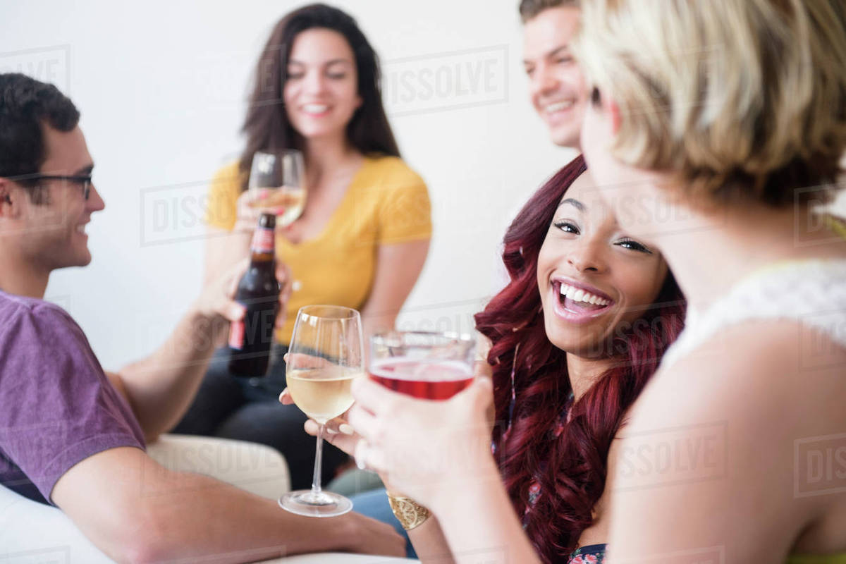 Smiling friends drinking at party - Royalty-free Stock Photo | Dissolve