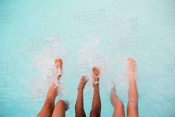 Legs of girls splashing feet in swimming pool - Royalty-free Stock ...