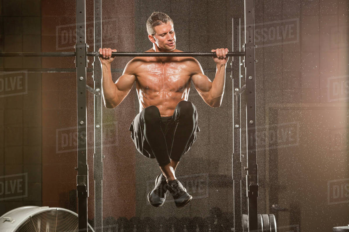 Caucasian man doing chin-up in gymnasium - Royalty-free Stock Photo ...