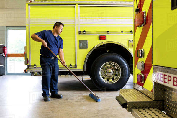 Chinese fireman sweeping floor near fire trucks - Royalty-free Stock ...