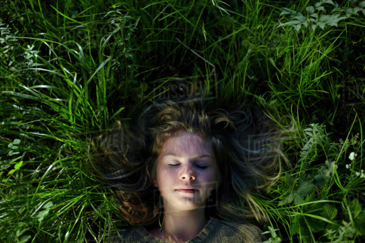 Caucasian girl laying in grass - Stock Photo - Dissolve