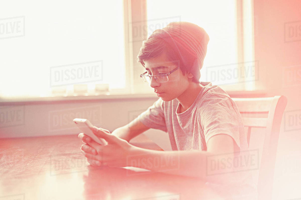 Boy texting on cell phone - Royalty-free Stock Photo | Dissolve