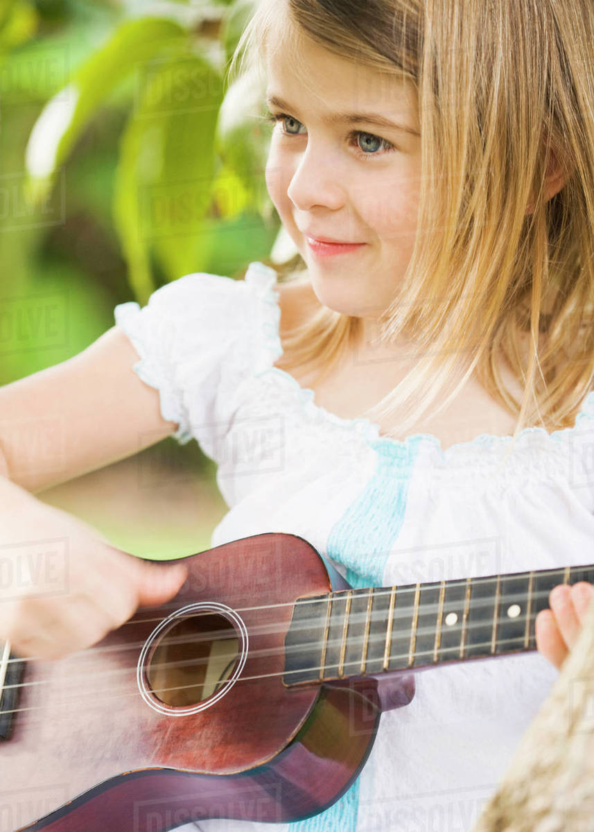 Girl playing ukulele - Stock Photo - Dissolve