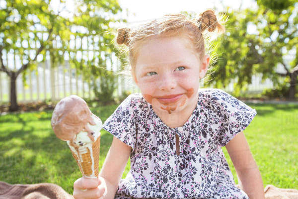 Caucasian girl with messy face eating ice cream cone - Royalty-free ...