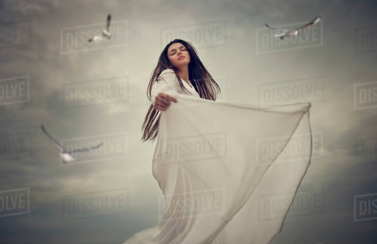 Birds flying near dancing Caucasian woman - Stock Photo - Dissolve