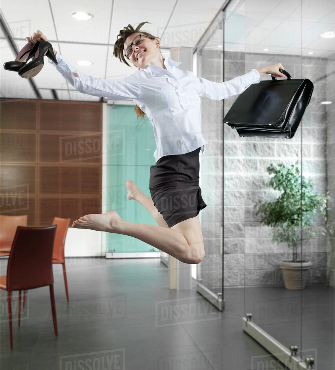 Caucasian businesswoman jumping in office - Royalty-free Stock Photo ...