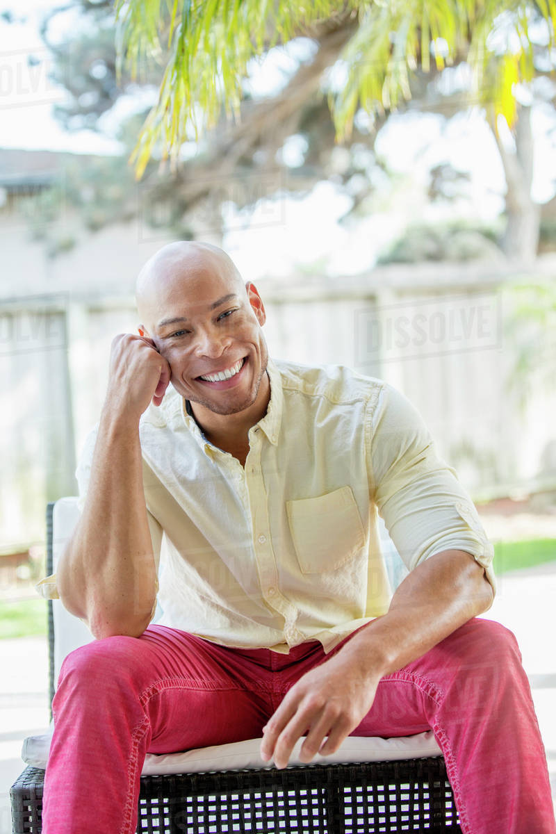 Mixed race man smiling in backyard - Royalty-free Stock Photo | Dissolve