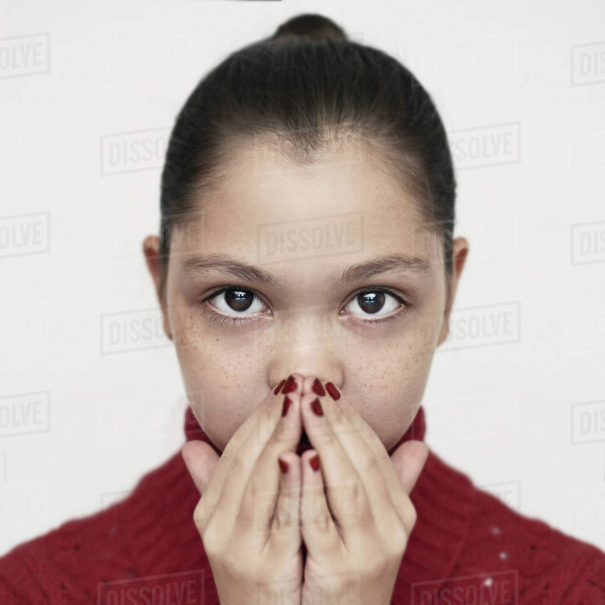 Caucasian girl covering mouth with hands - Stock Photo - Dissolve
