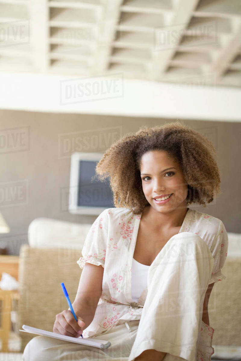 African woman writing on note pad - Royalty-free Stock Photo | Dissolve