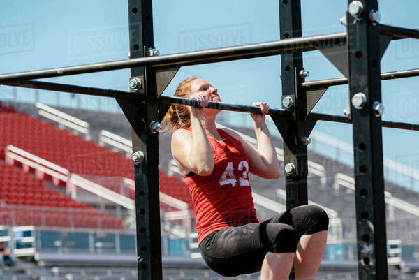 Woman doing chin-ups outdoors - Royalty-free Stock Photo | Dissolve