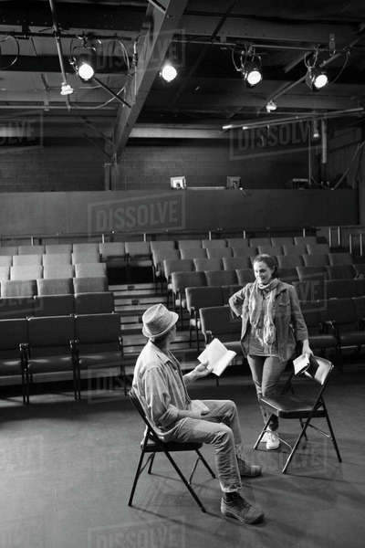 Actors rehearsing with scripts in theater - Stock Photo - Dissolve