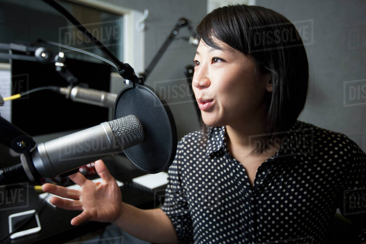 Asian woman talking into microphone - Royalty-free Stock Photo | Dissolve