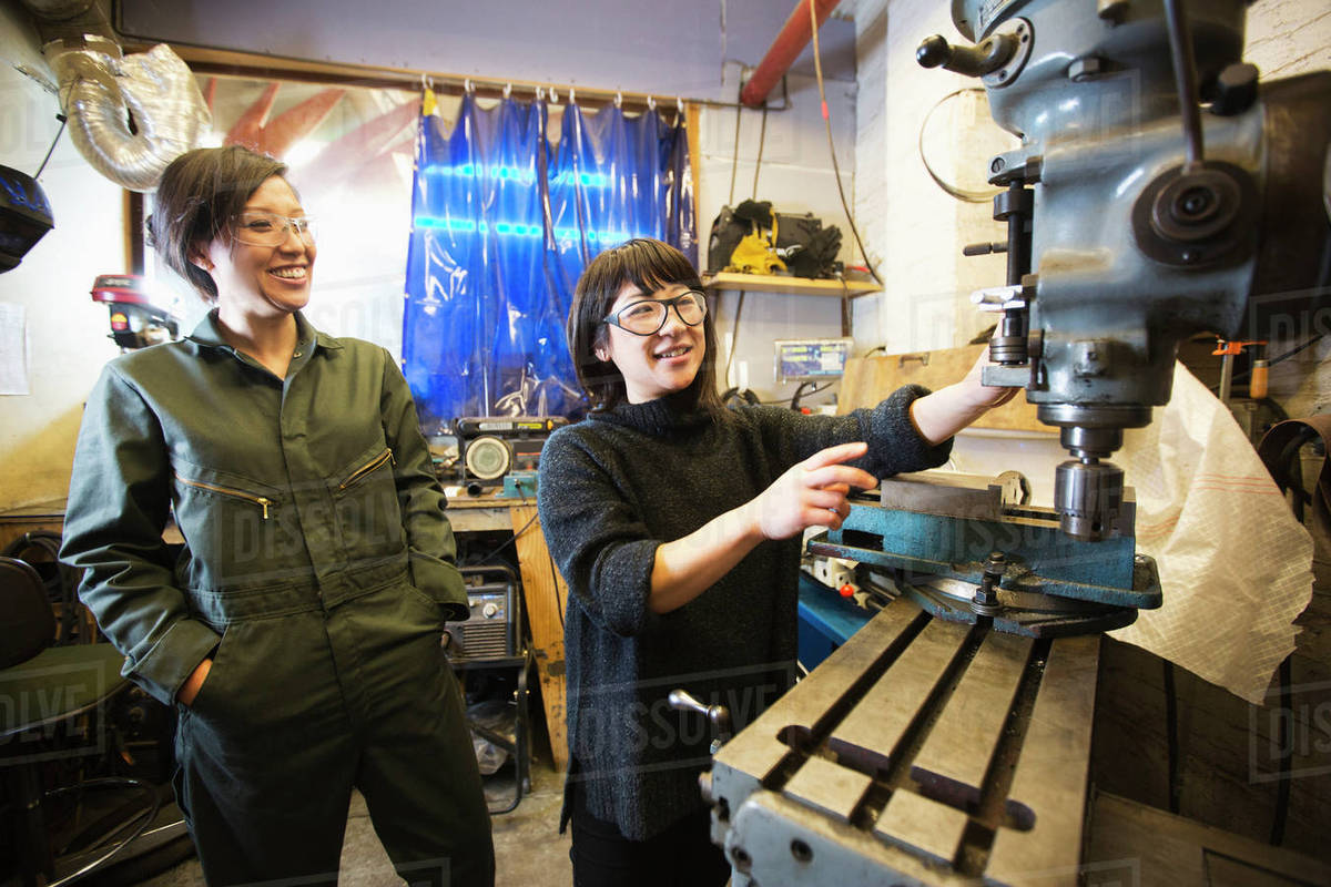 Women using machinery in workshop - Royalty-free Stock Photo | Dissolve