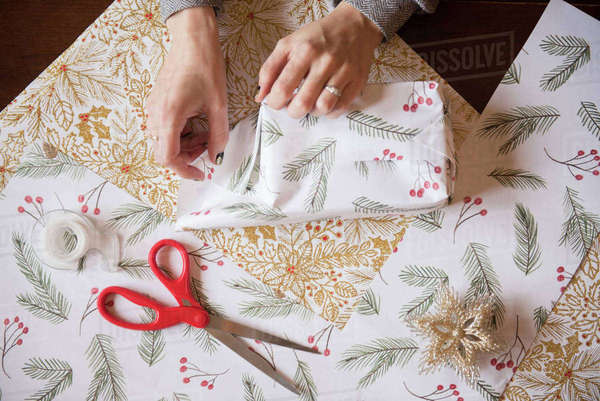 Hands of woman wrapping Christmas gifts - Stock Photo - Dissolve