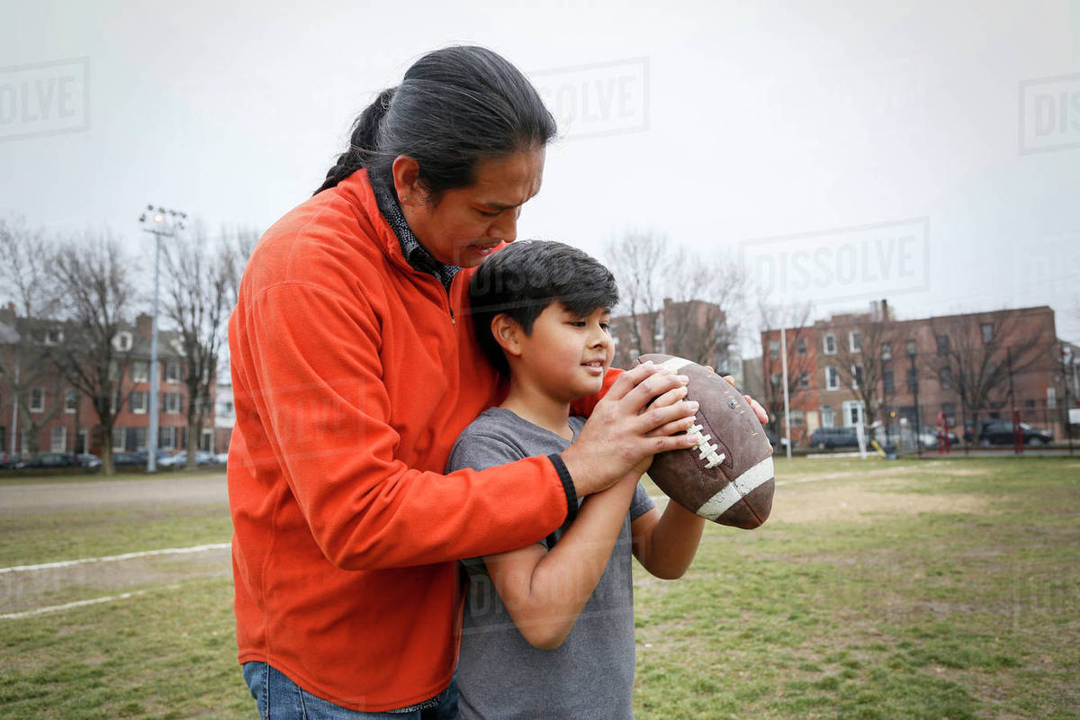 Native American father teaching son to throw football - Stock Photo ...